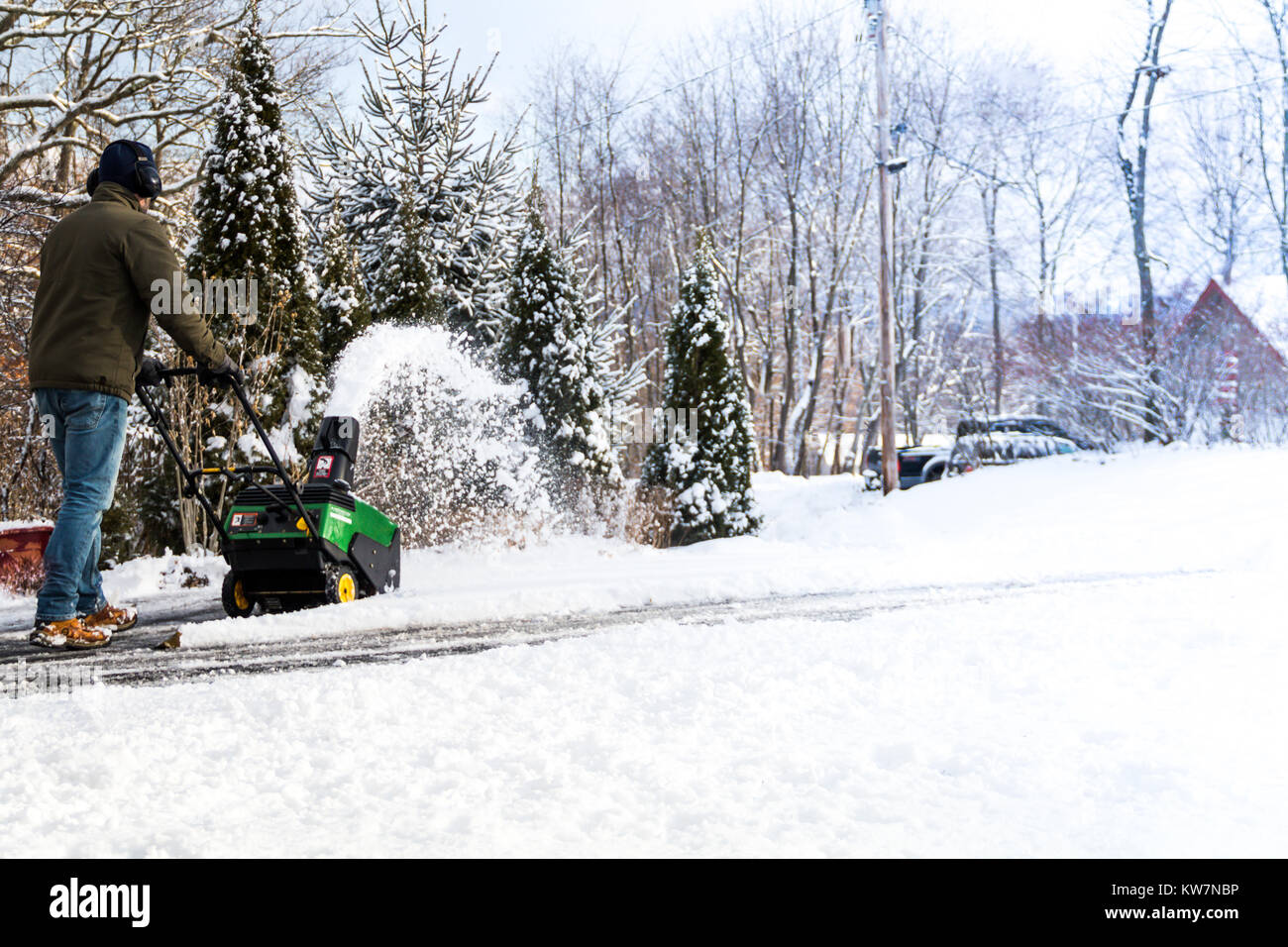 Side view of snowblower in action in residential neighborhood in NJ ...