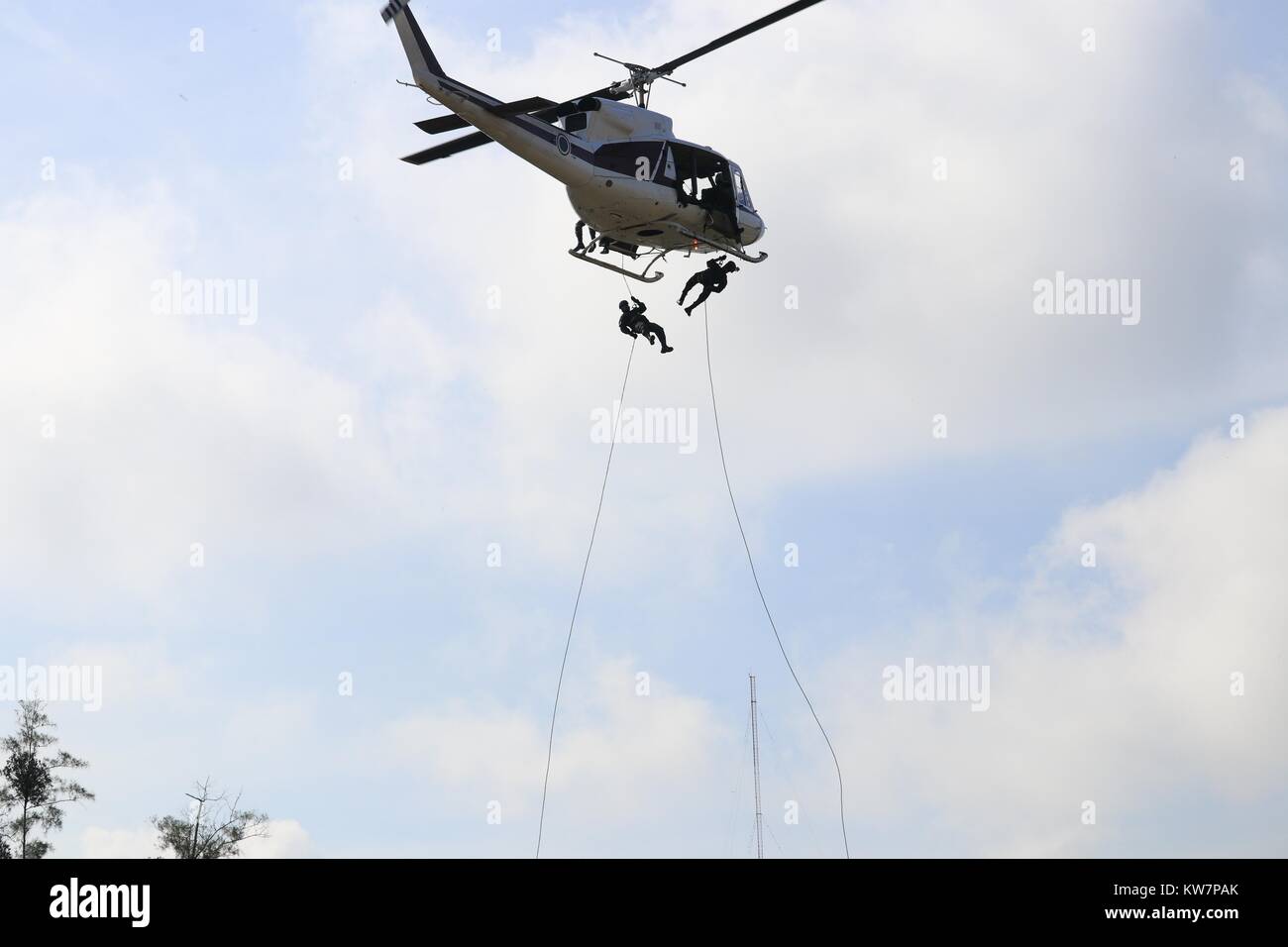 Soldier rappelling from helicopter in blue sky with blur propeller ...