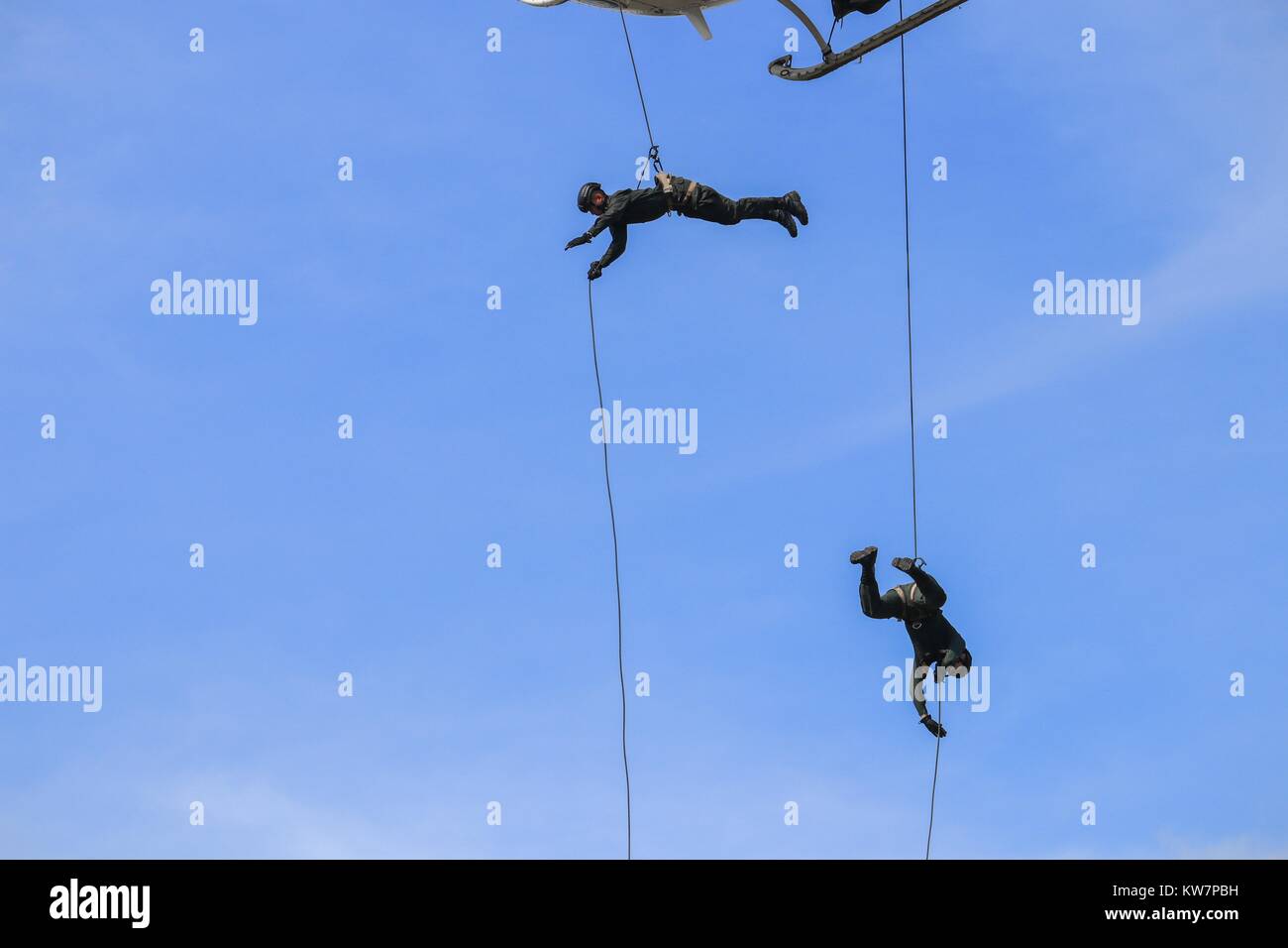 Soldier rappelling from helicopter in blue sky Stock Photo - Alamy