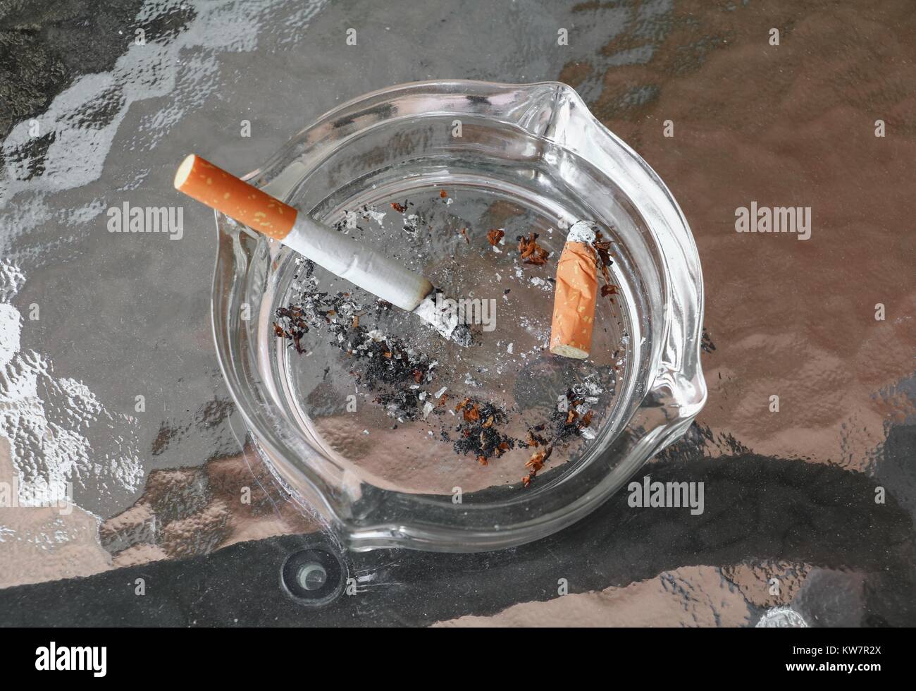 Cigarette in ashtray Placed on table glass Stock Photo - Alamy