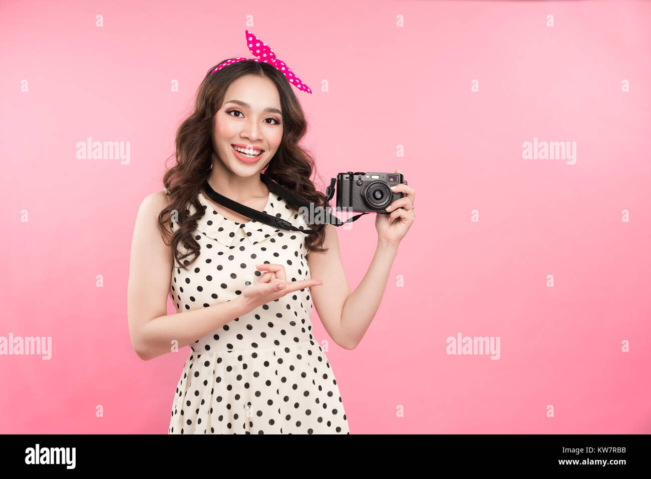 Young beautiful woman with camera on pink background Stock Photo - Alamy