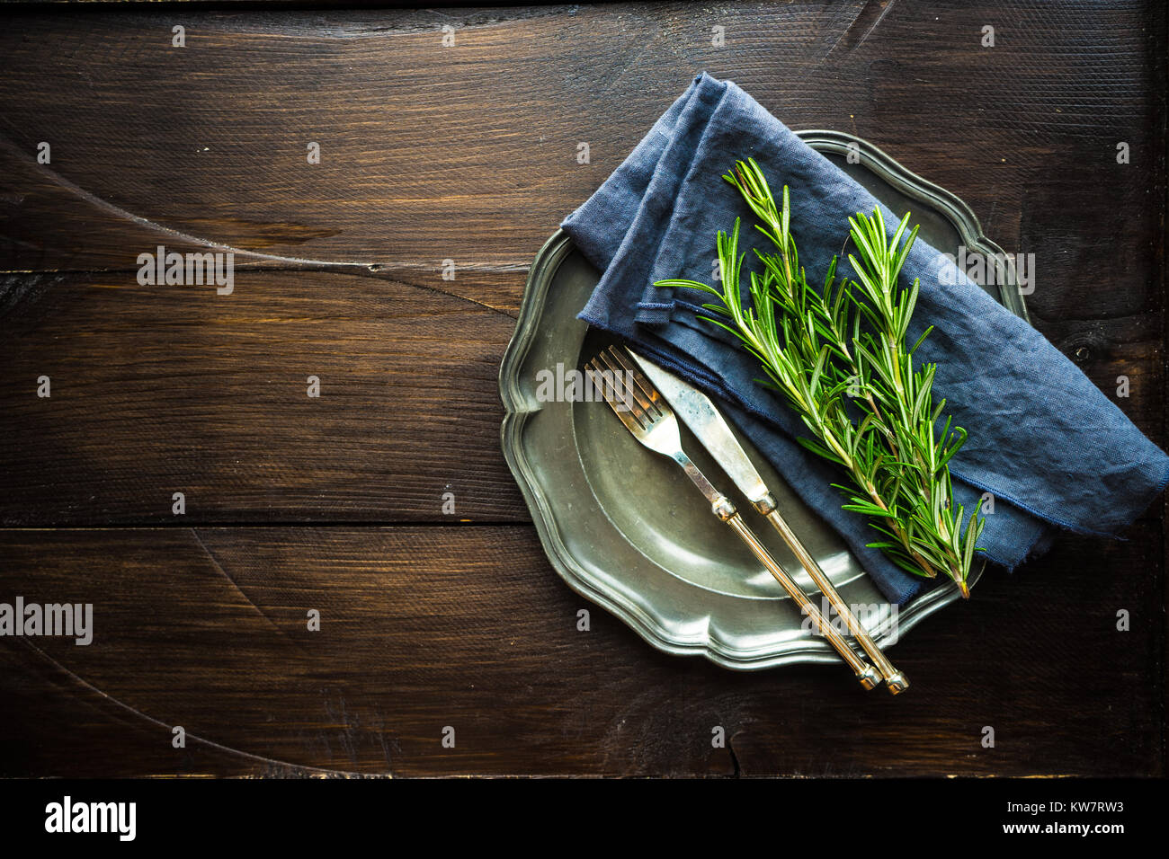 Rustic table setting with vintage tableware and rosemary herb on a ...