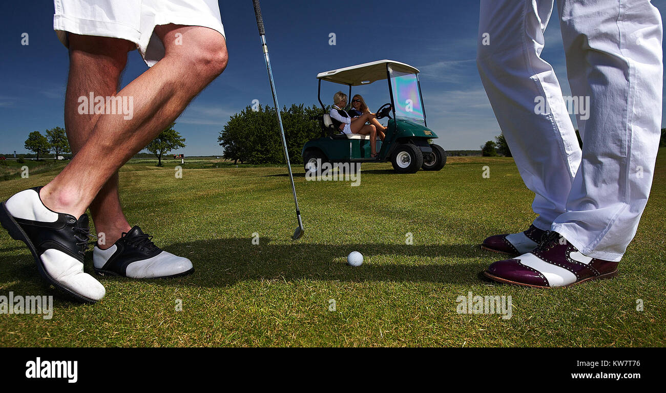 Two golf player on a green field Stock Photo - Alamy