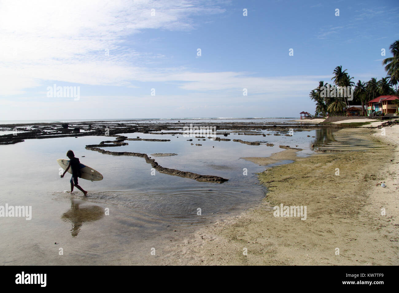 Serfer walking on the Pantai Sorake beach in Nias island, Indonesia ...