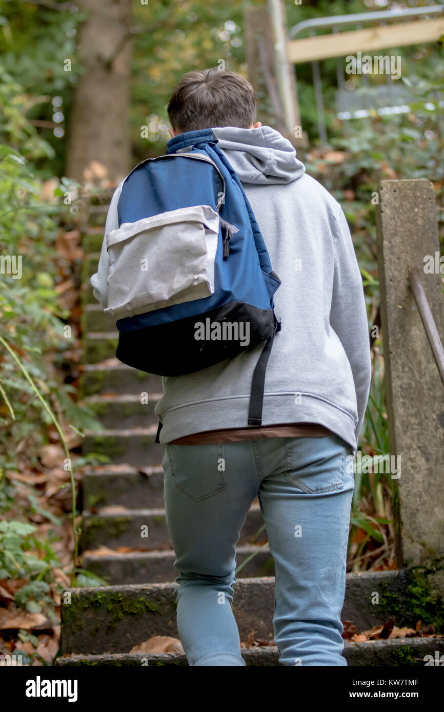 Teenage boy walking up outside concrete steps on an autumn day Stock ...