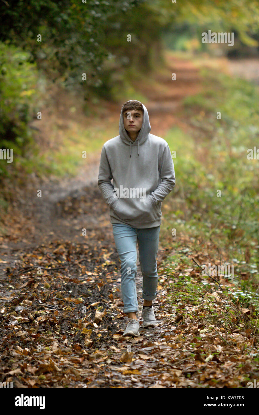 A young adult male walking alone outside on an autumn day Stock Photo ...