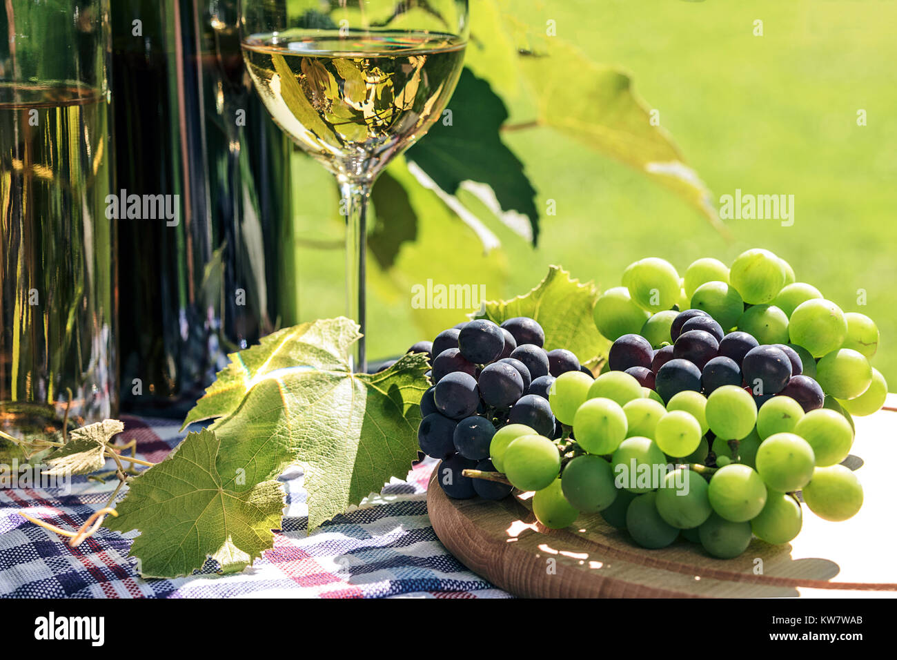 Bunch of fresh grapes next to wine in a bottle and wineglass on the ...