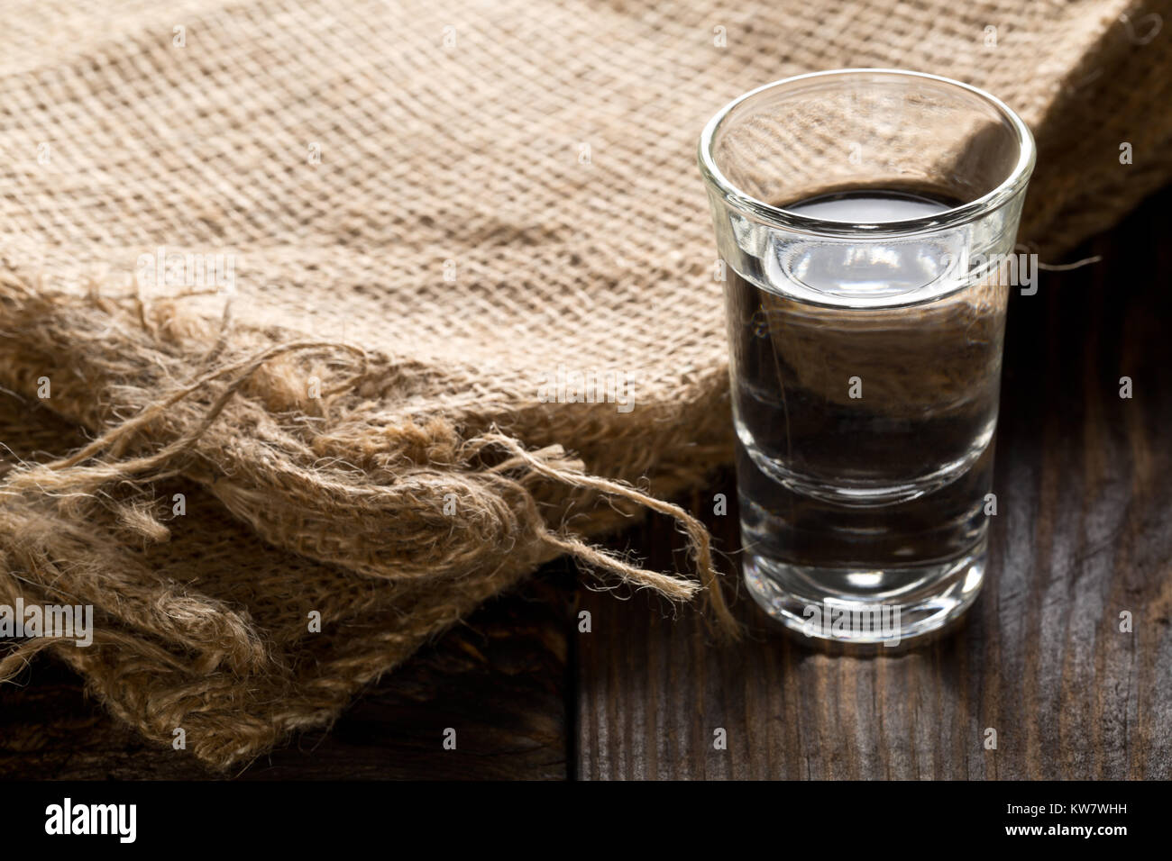 German hard liquor Korn Schnapps in shot glass with burlap sack on ...