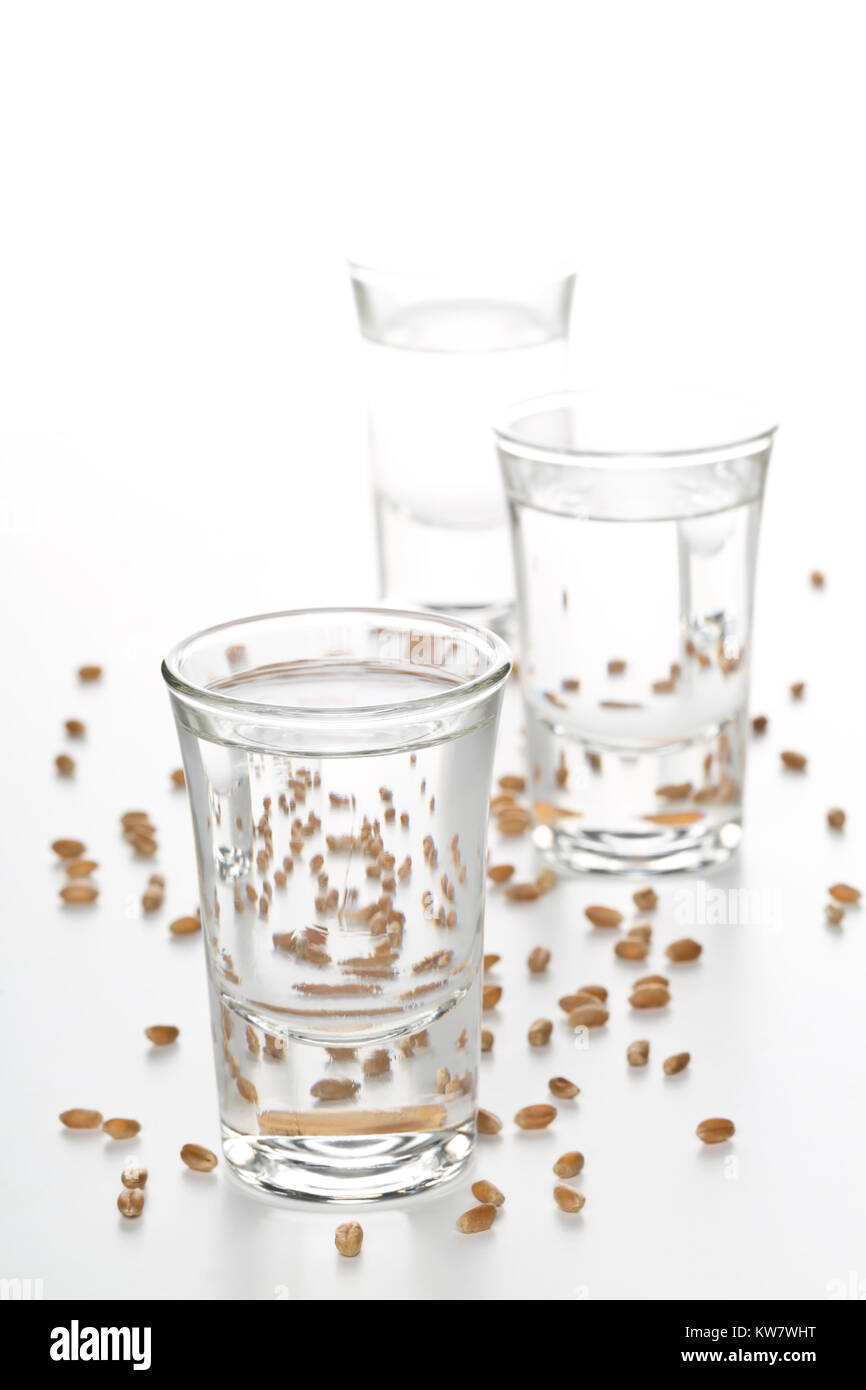 German hard liquor Korn Schnapps in shot glasses with wheat grains over ...