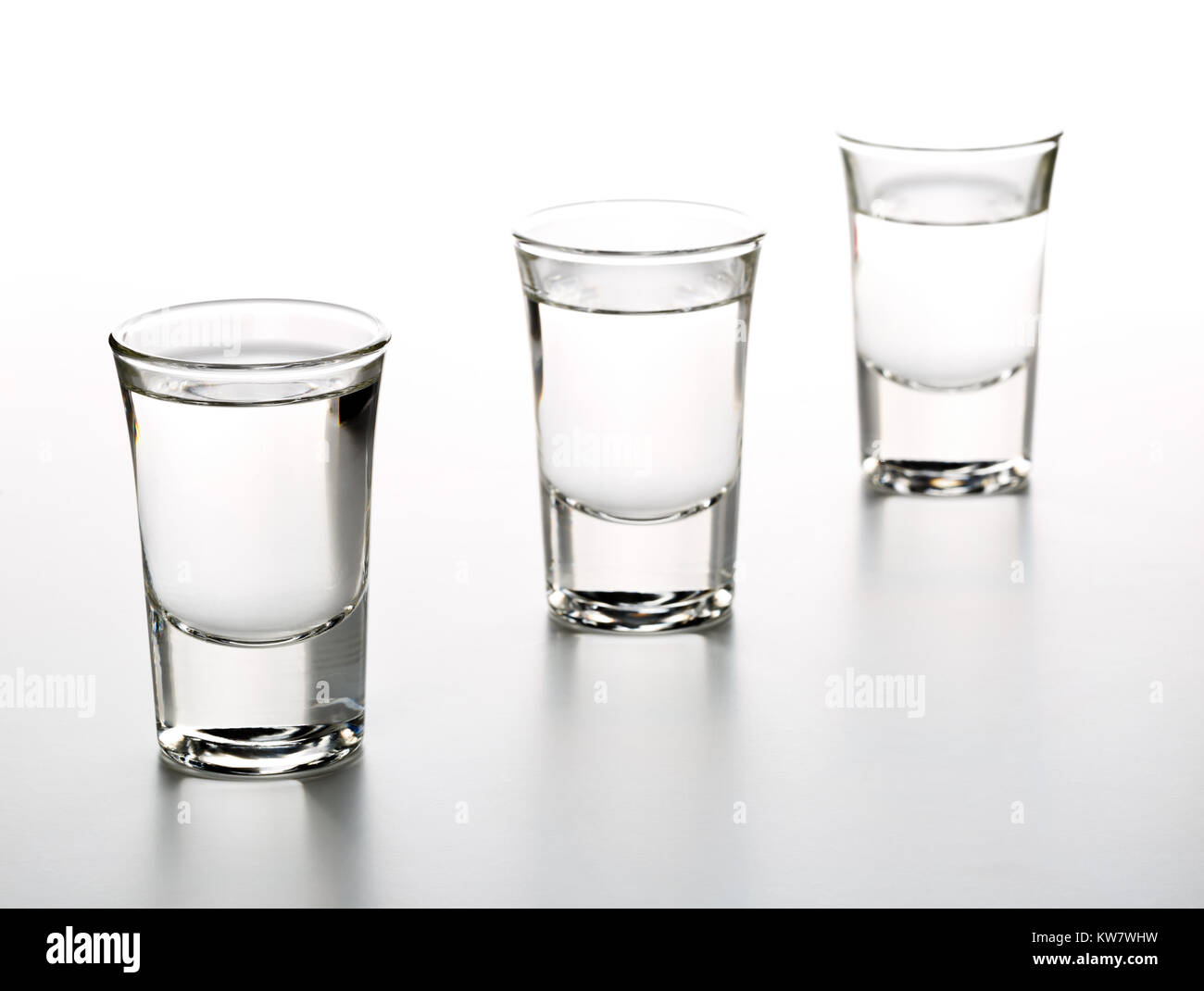 German hard liquor Korn Schnapps in shot glasses over white background ...