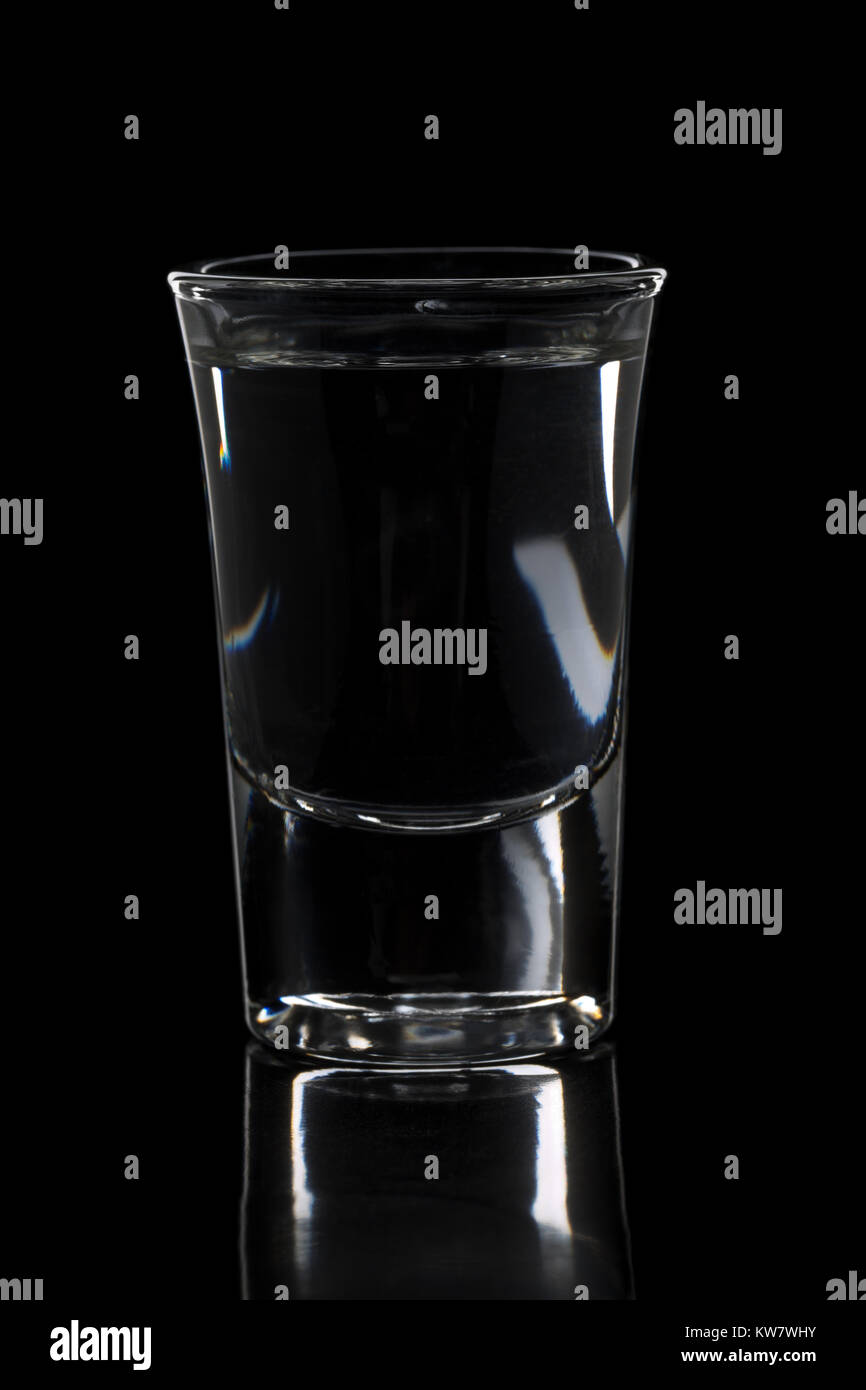 German hard liquor Korn Schnapps in shot glass over black background ...