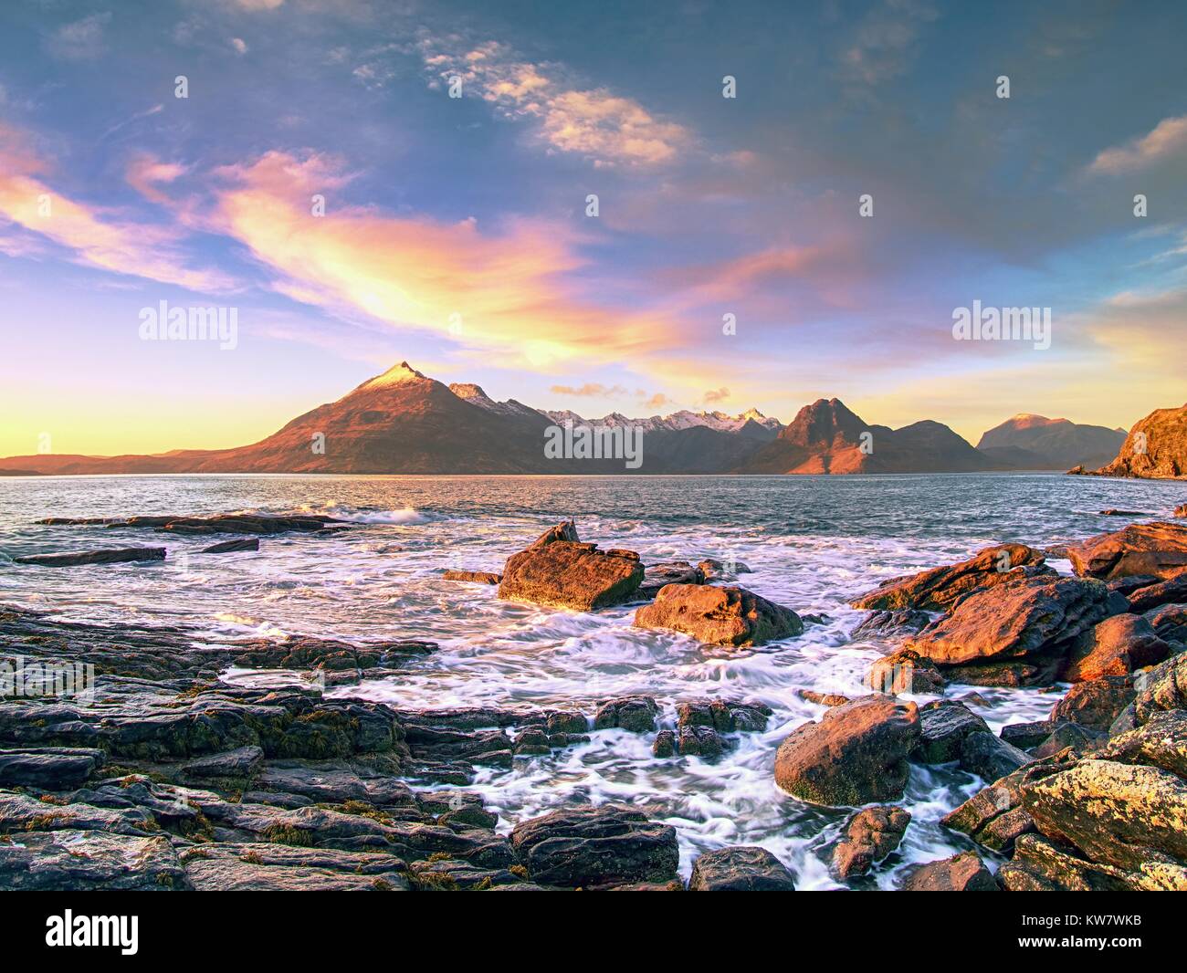 Evening rocky shore with sea water and large cracked rocks with erosion ...