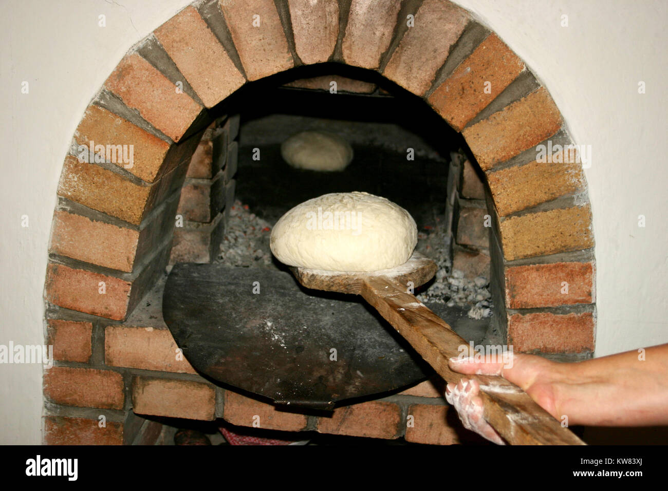 Baking loaves of bread in traditional brick oven Stock Photo - Alamy