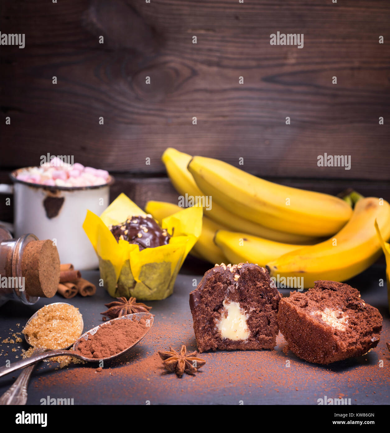 banana muffin with a filling cut in half on a black background, behind ...