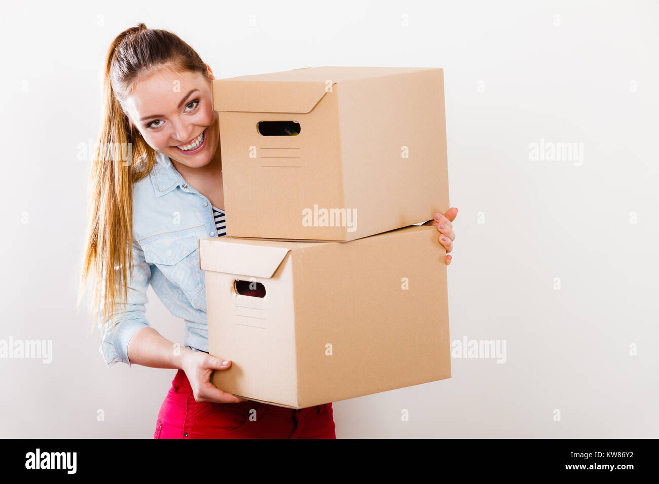 Happy woman moving in carrying cartons boxes. Young girl unpacking at ...
