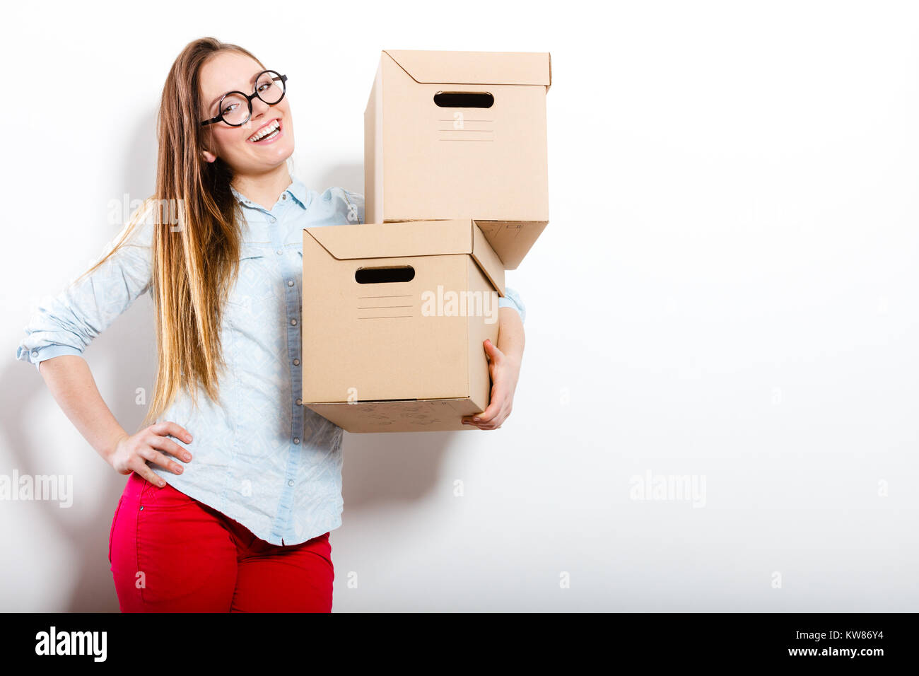 Happy woman moving in carrying cartons boxes. Young girl arranging ...