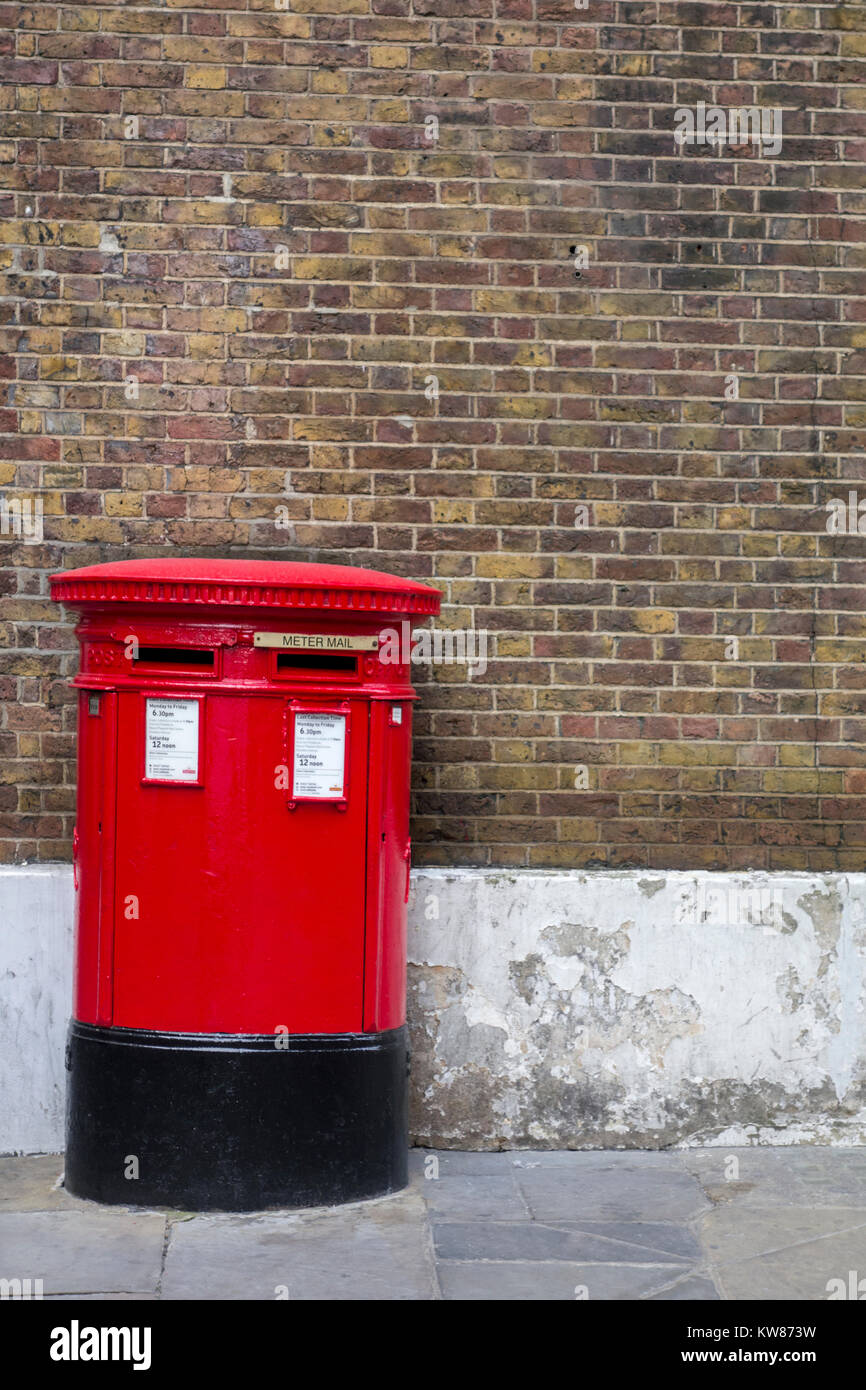 British red post box against a brick wall background in London Stock ...
