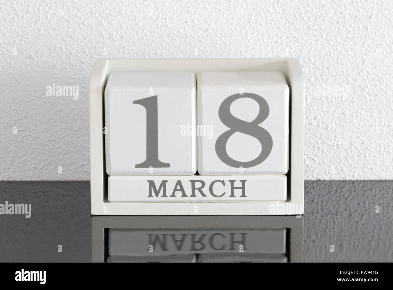 White block calendar present date 18 and month March on white wall ...