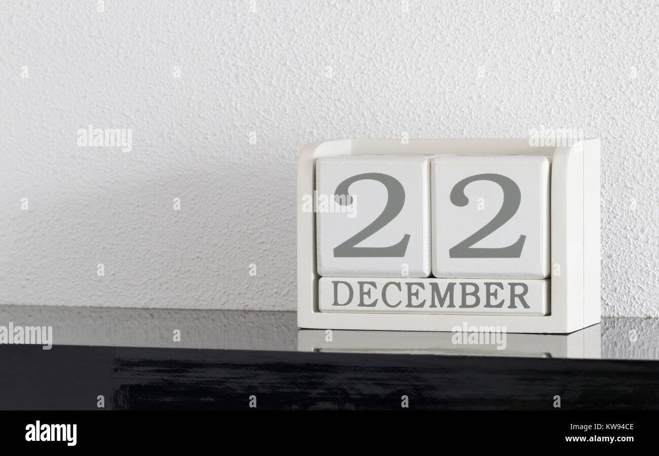 White block calendar present date 22 and month December on white wall ...