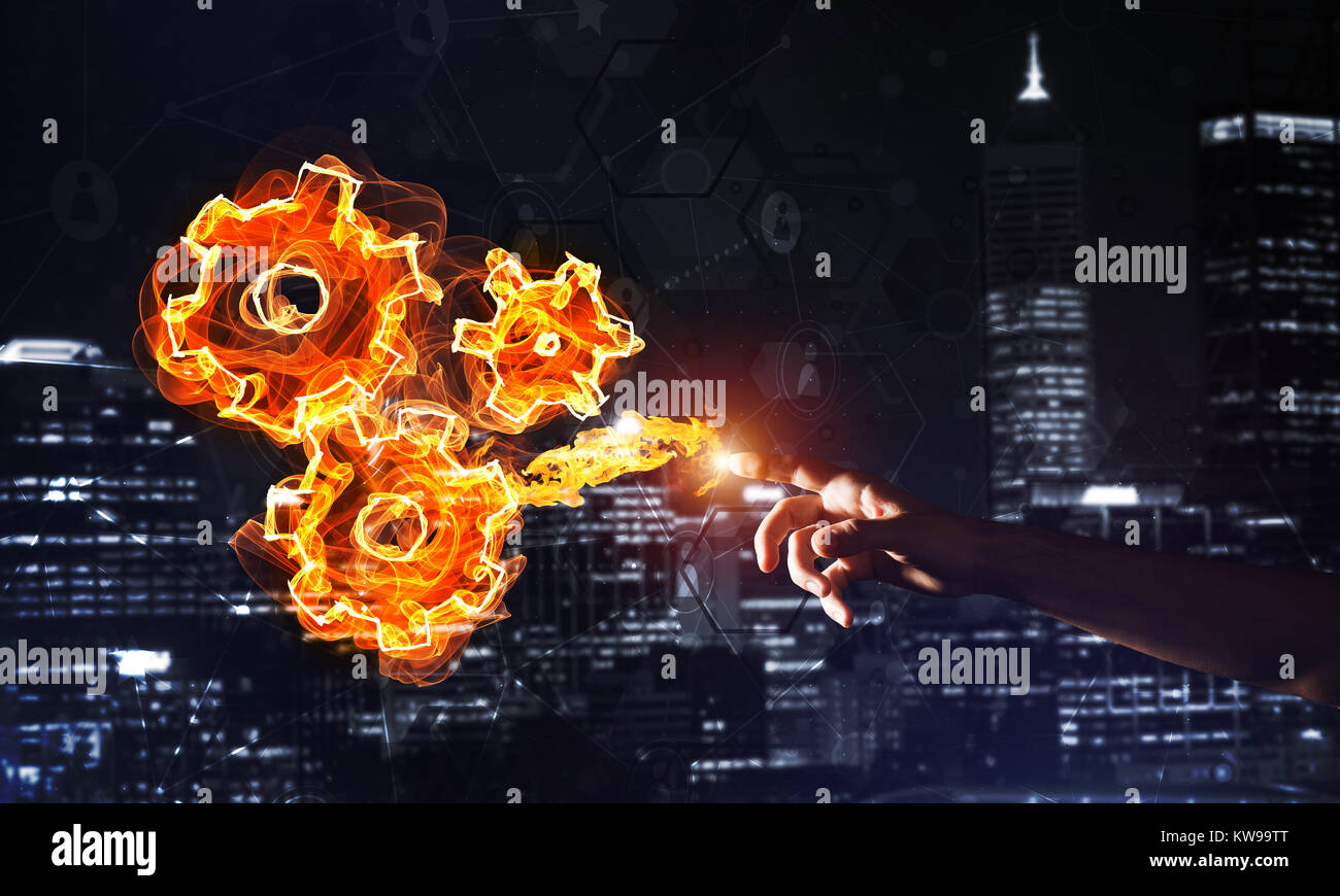 Fire burning gear mechanism on night city background Stock Photo - Alamy