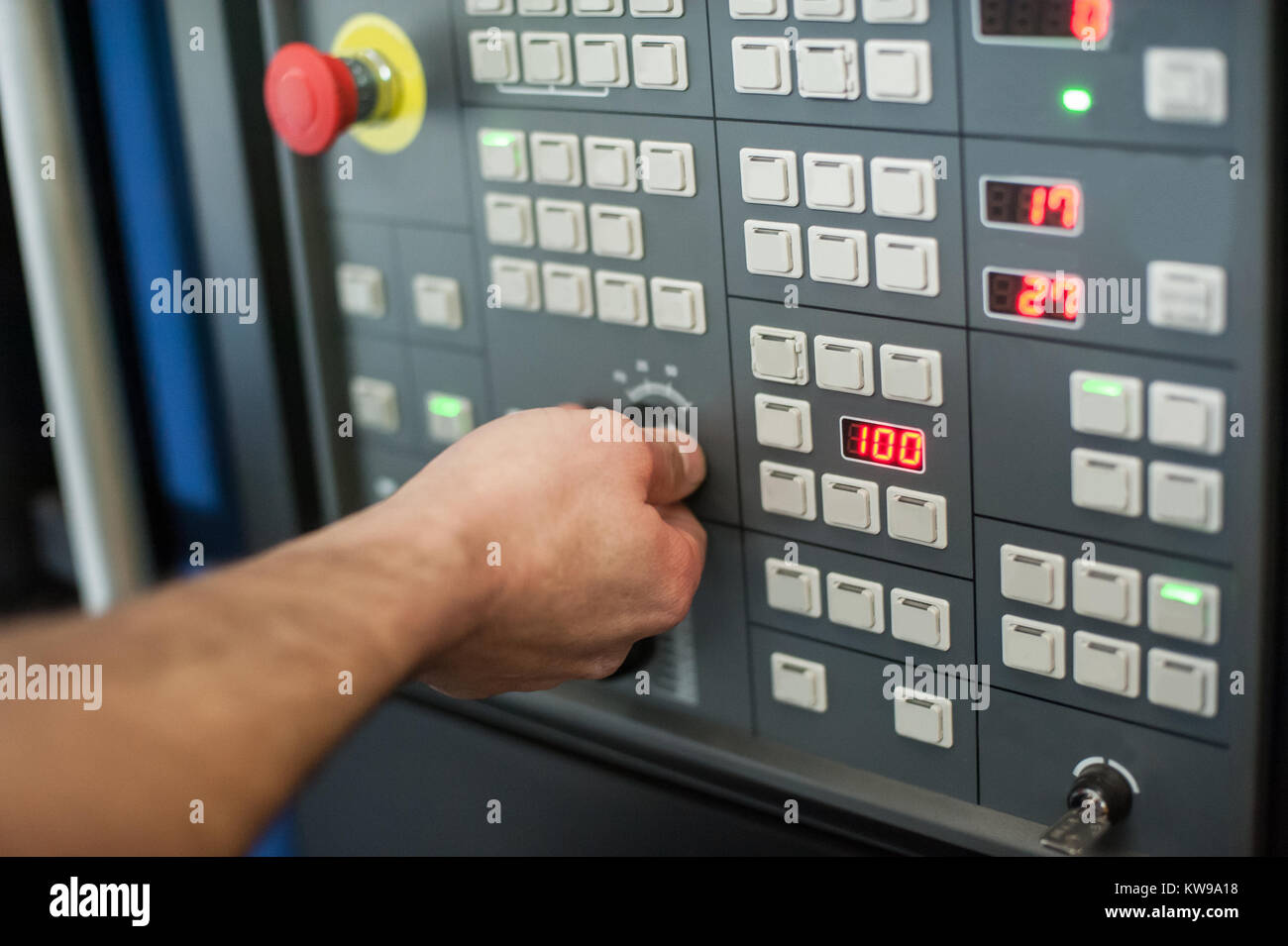 Industrial machinery mechanics and factory worker adjusts the control ...
