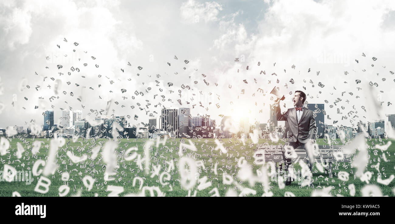 Young businessman sitting on bench and screaming emotionally in ...