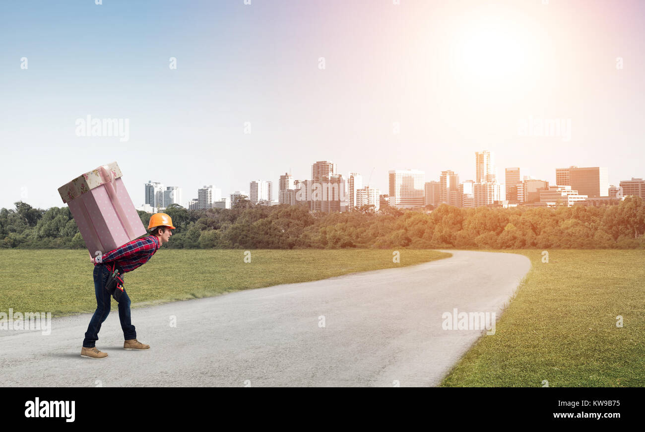 Man carrying on his back large box Stock Photo - Alamy
