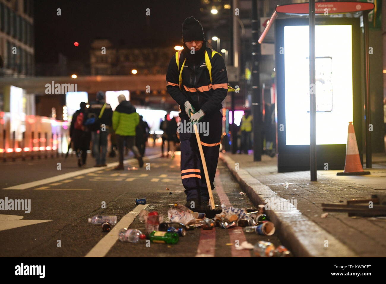 A worker cleans the streets in central London as people make their way ...