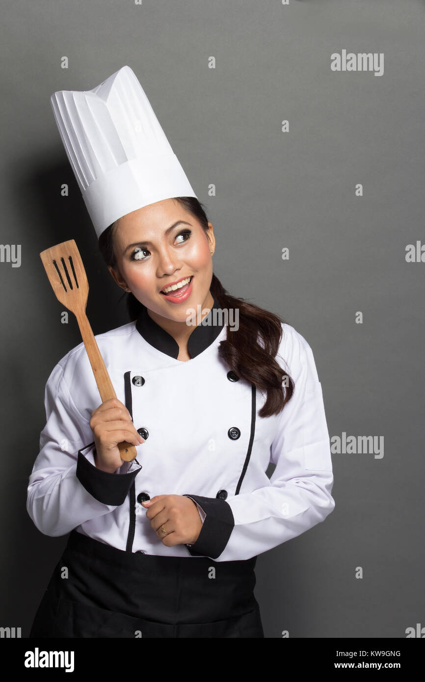 portrait of Pretty woman Chef in action, hold spatula thinking Stock ...