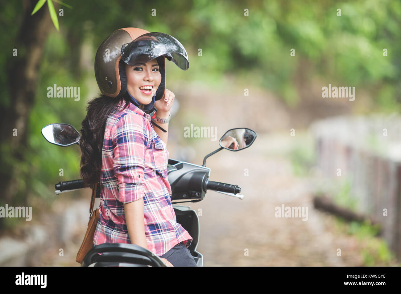 A portrait of a young asian woman riding a motorcycle in a park Stock ...