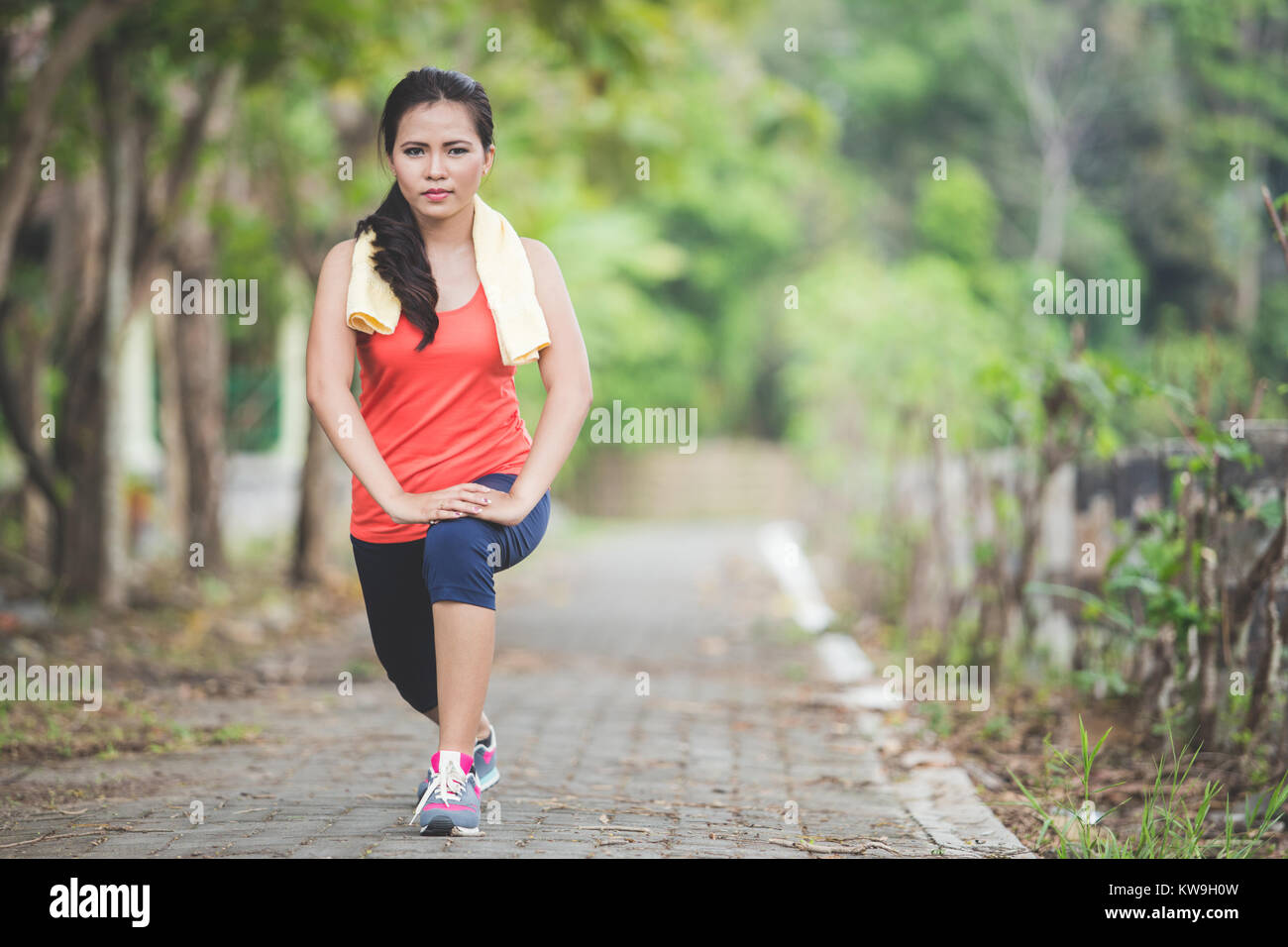 A portrait of a young asian woman doing excercise outdoor in a park ...