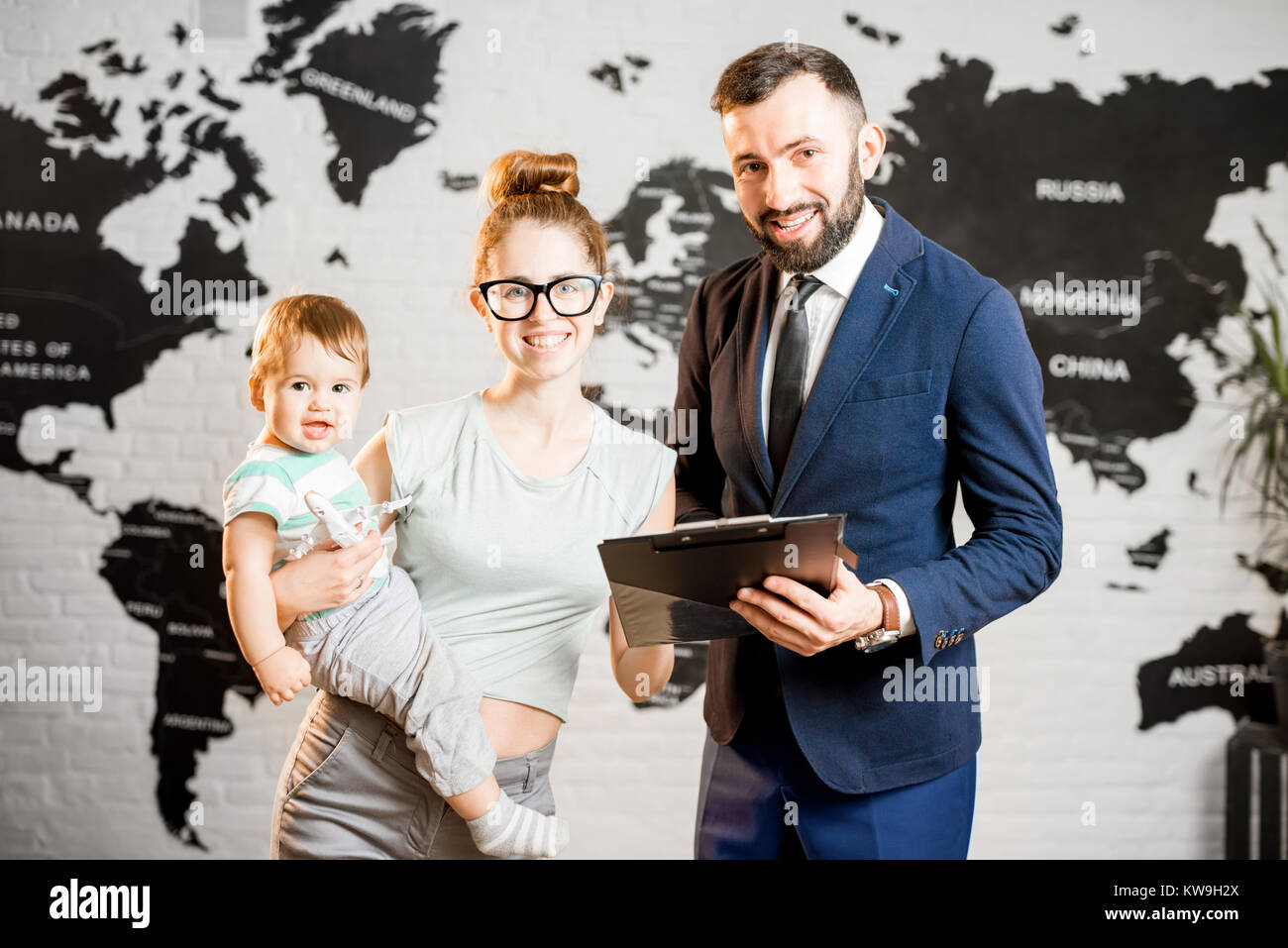 Happy mother and baby boy choosing tour for a summer vacation with male ...