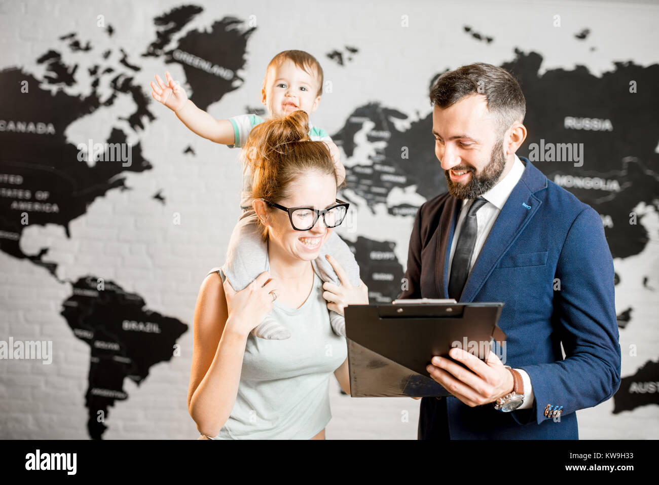 Happy mother and baby boy choosing tour for a summer vacation with male ...