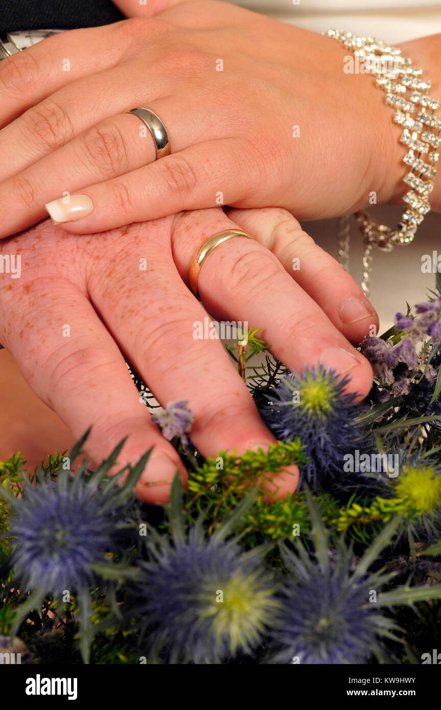 the hands of a bride and groom newly weds showing off their wedding ...
