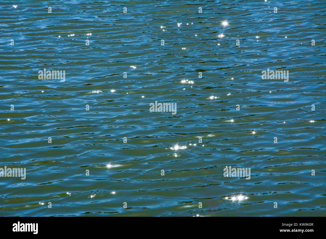 Sun rays reflecting star effect in water surface Stock Photo - Alamy