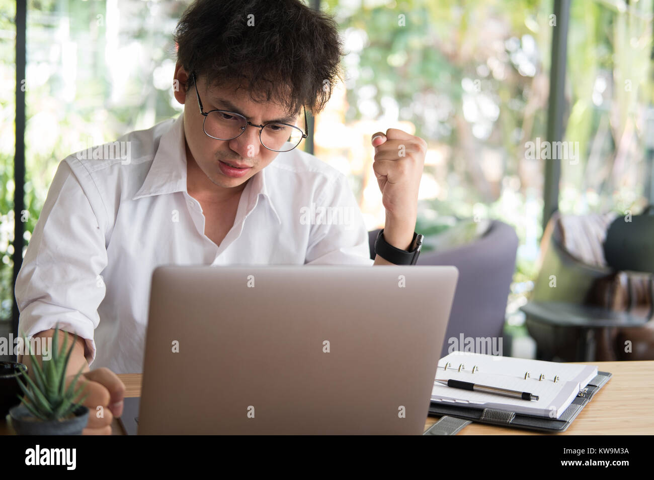 asian student using computer for learning leasson online at cafe. angry ...