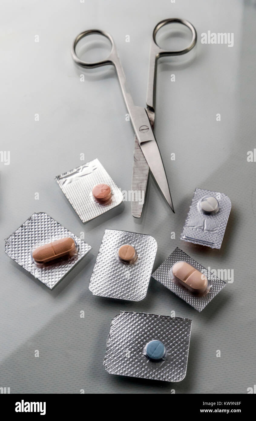 Scissors next to several blister cut, conceptual image Stock Photo - Alamy