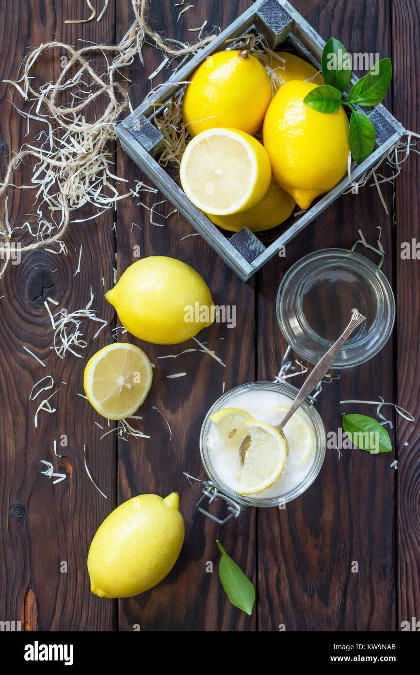 Slices of fresh lemon in sugar and fresh lemons on the kitchen table ...