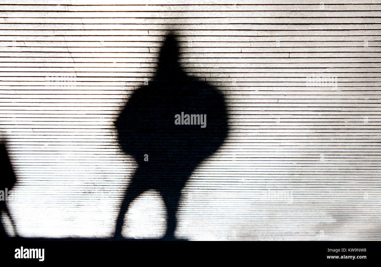 Blurry crooked shadow silhouette of a person walking city street ...