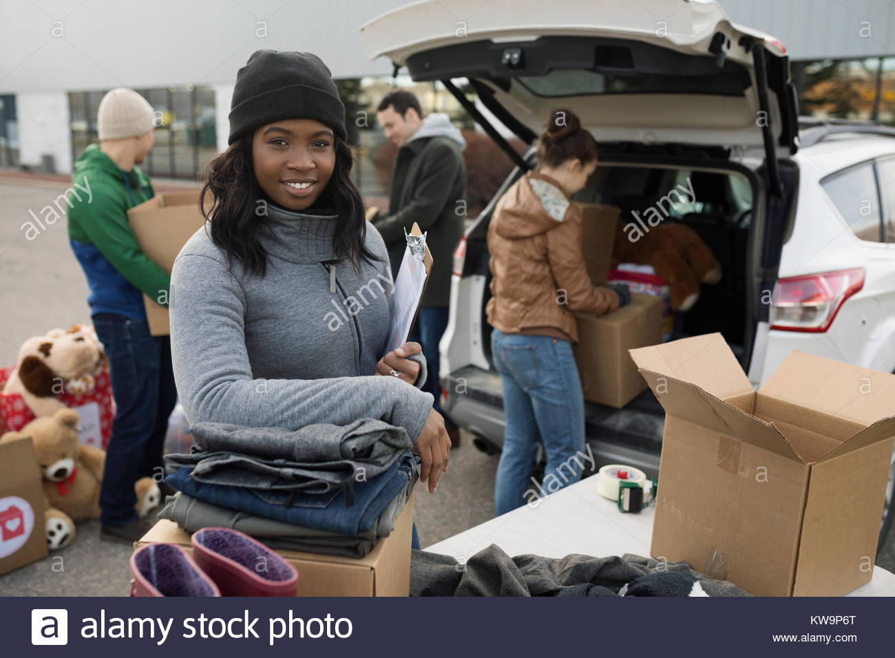 Portrait smiling,confident young female volunteer loading donations ...