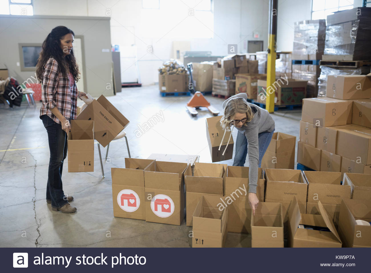 Female volunteers preparing donation boxes in warehouse Stock Photo - Alamy