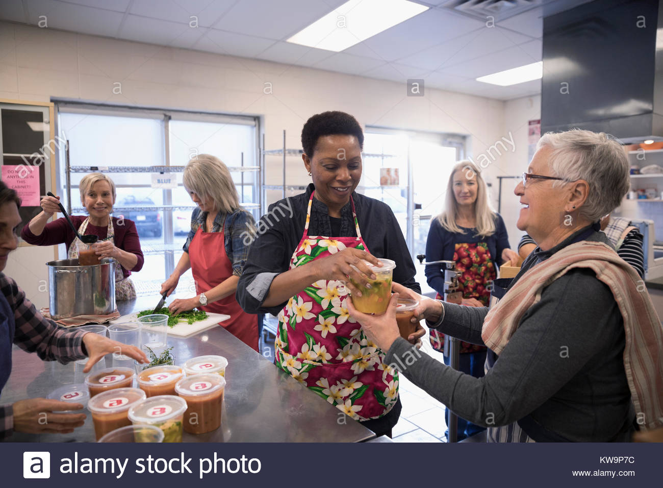 Female volunteers packaging soup containers in soup kitchen Stock Photo ...