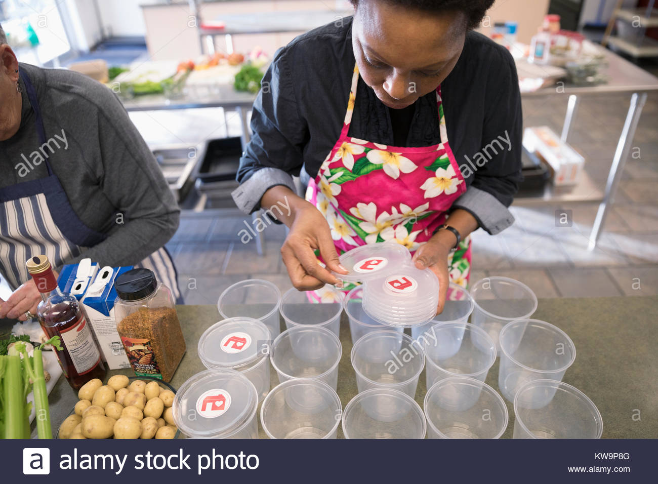 Female volunteer preparing soup containers in soup kitchen Stock Photo ...