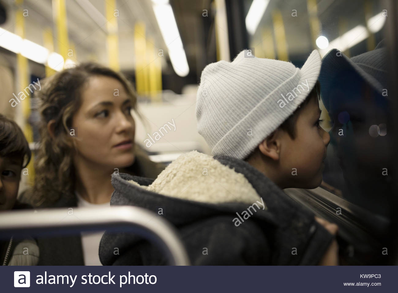 Curious boy riding bus with mother,looking out window Stock Photo - Alamy