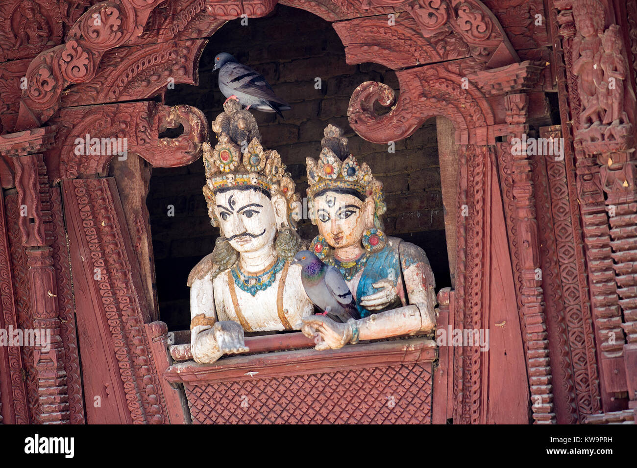 Pigeons sit on brightly painted wooden sculptures of the the Hindu god ...
