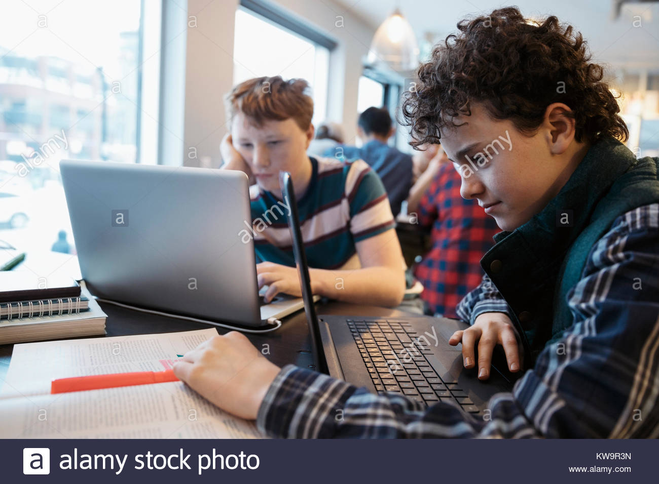 Focused high school boy students studying at laptops in cafe Stock ...