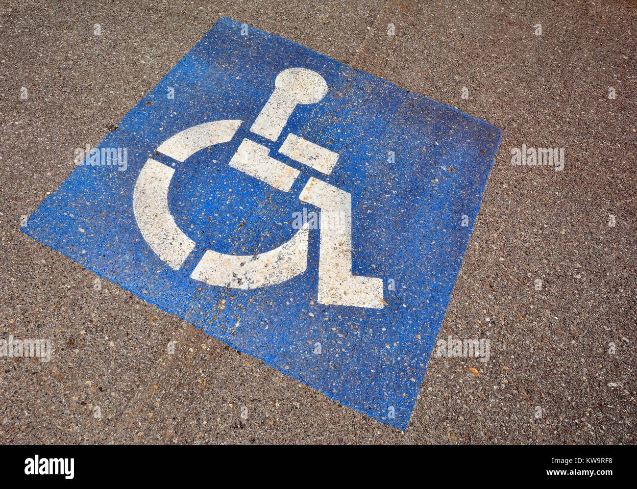 Disabled blue parking sign painted on dark asphalt Stock Photo - Alamy