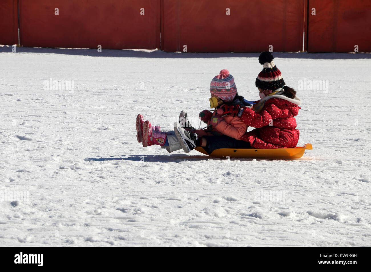 Two children tobogganing Stock Photo - Alamy