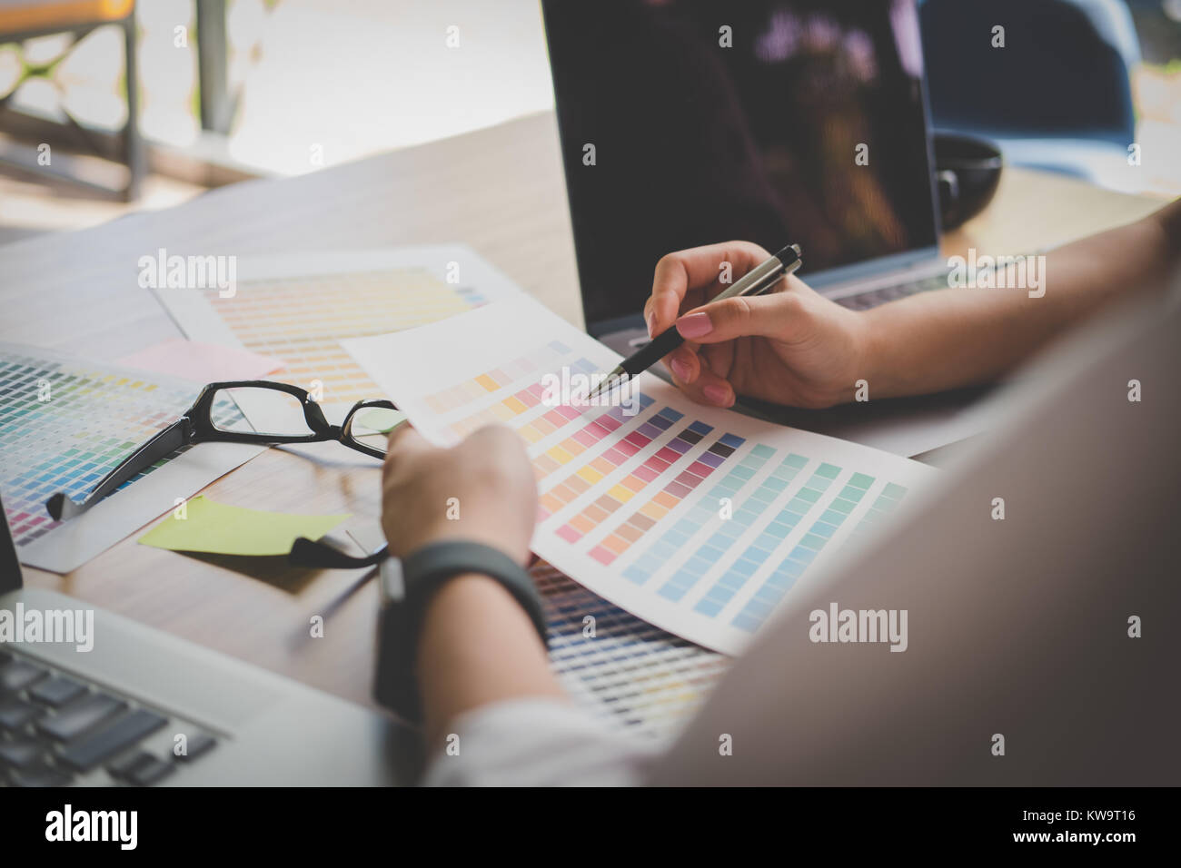 graphic or interior designer choosing color from swatch sample or ...