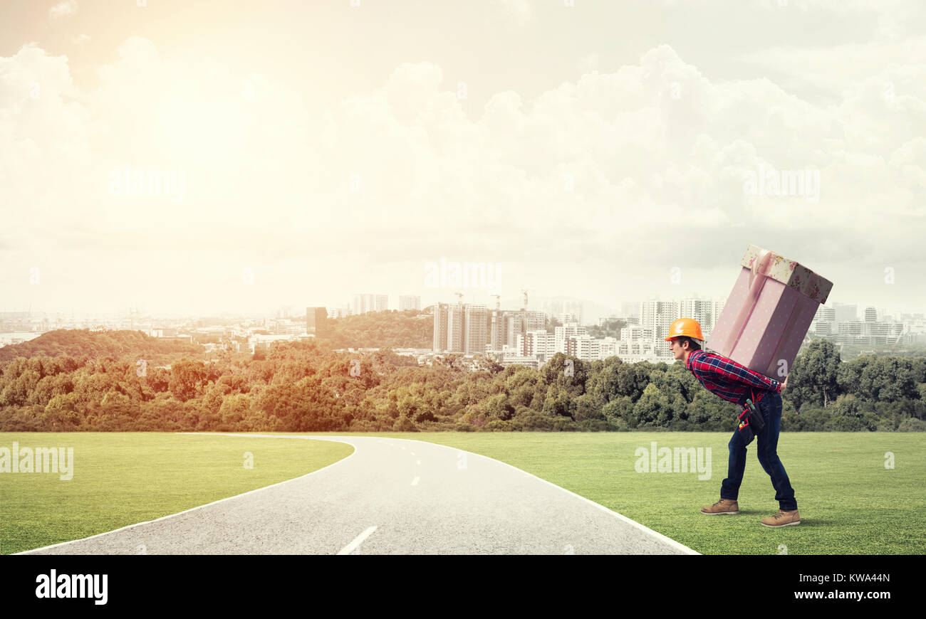 Man carrying on his back large box Stock Photo - Alamy
